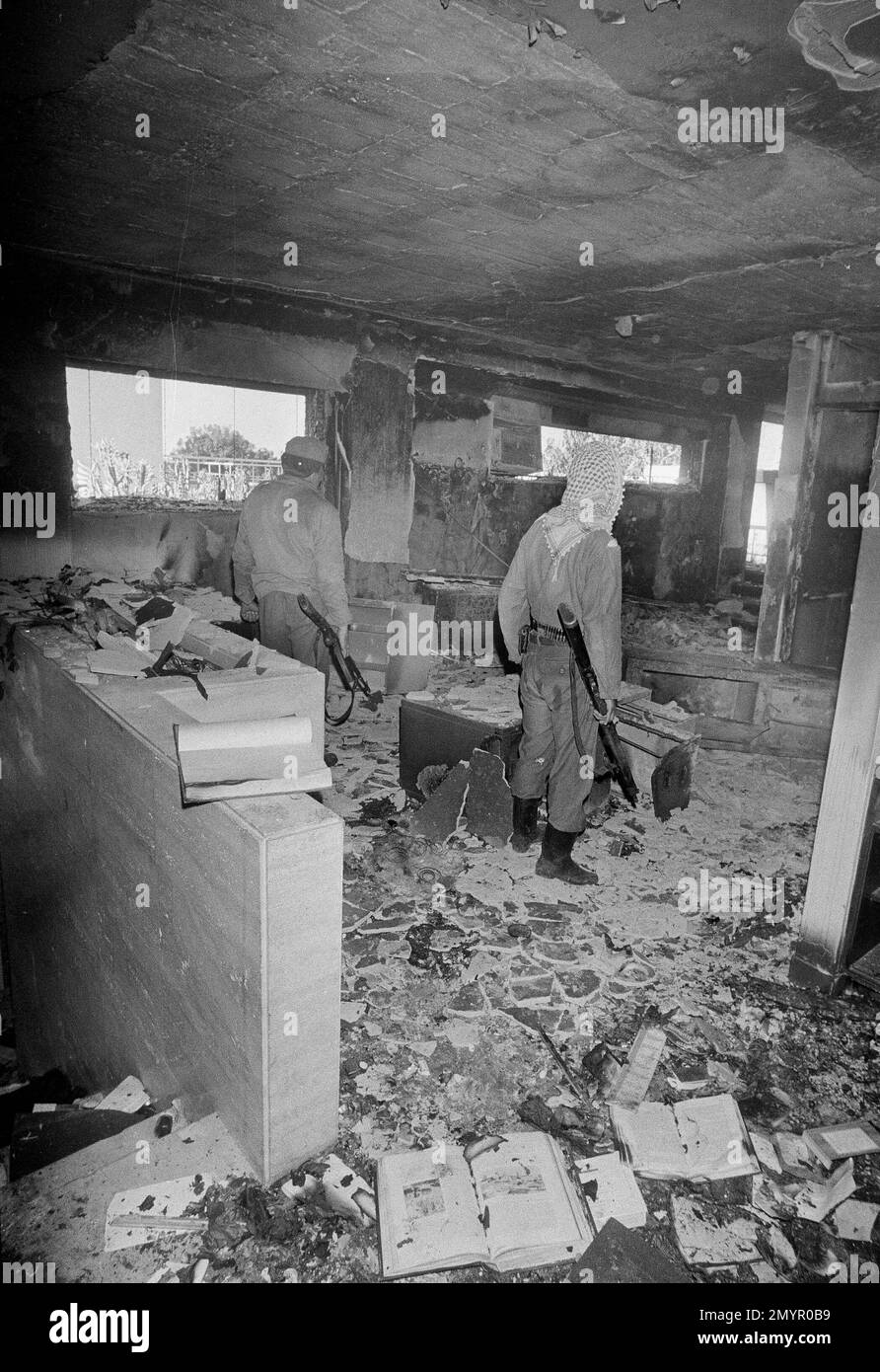 Two Palestinian Liberation Army troopers seen at the looted and burned ...