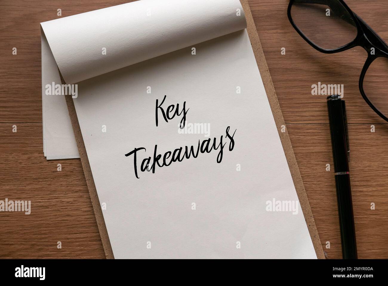 Pen, glasses and clipboard with a paper written with Key Takeaways ...