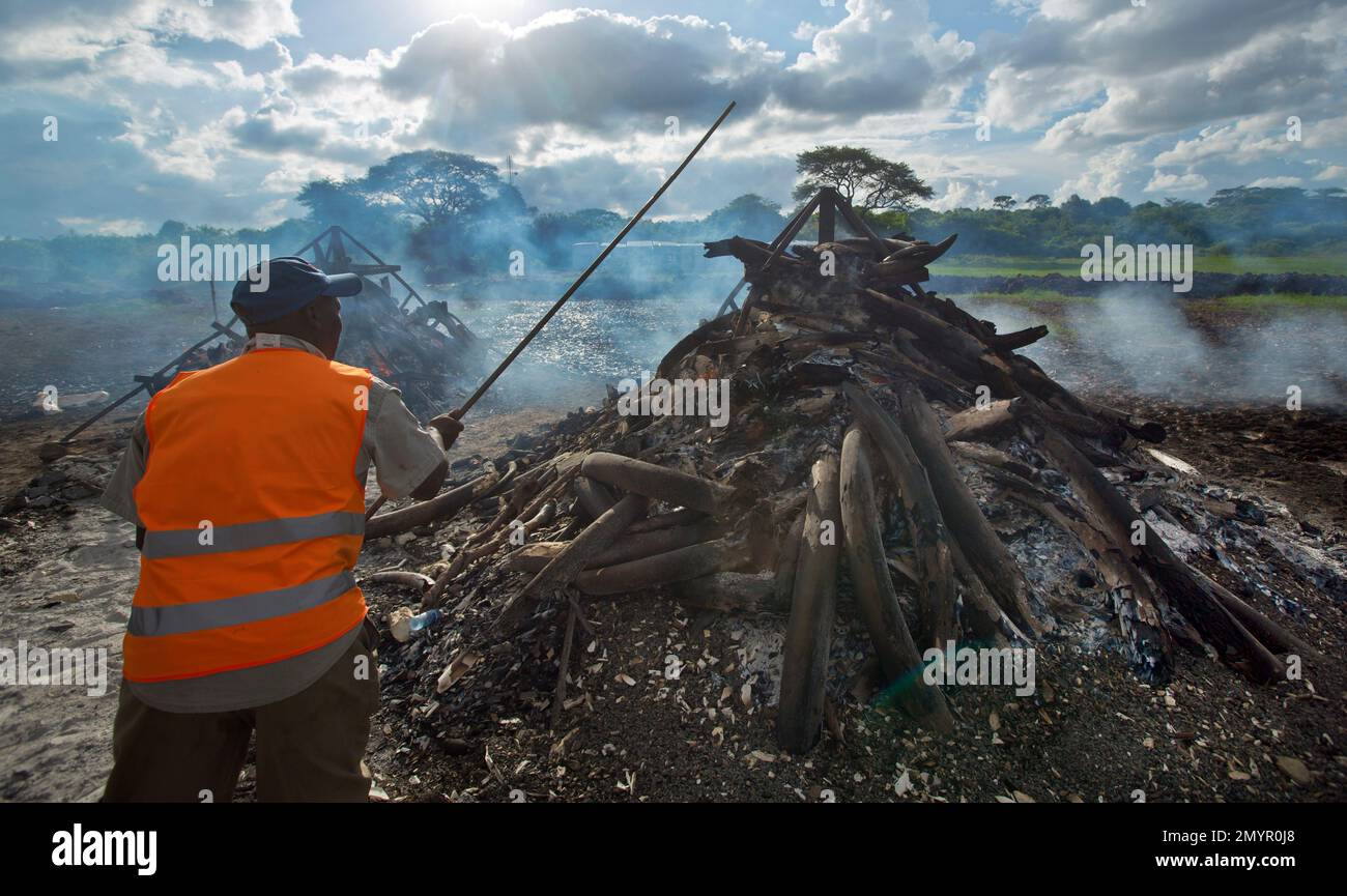 Contractor Peter Mungai uses a metal rod to break some of the mostly ...