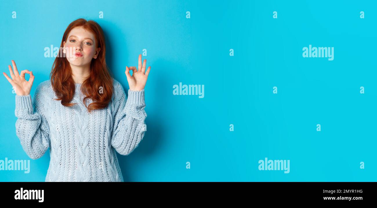 Redhead teenage girl showing okay signs, looking satisfied and proud ...