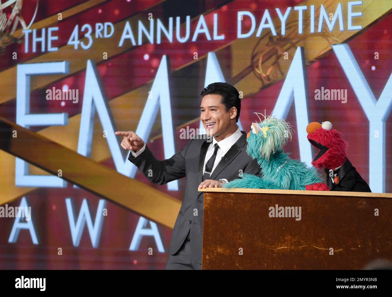 Mario Lopez, from left, Rosita, and Elmo present the award for ...