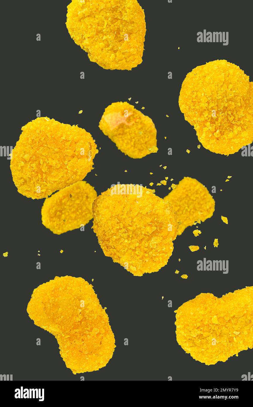 Falling nuggets isolated on a black background, selective focus. Fresh ...