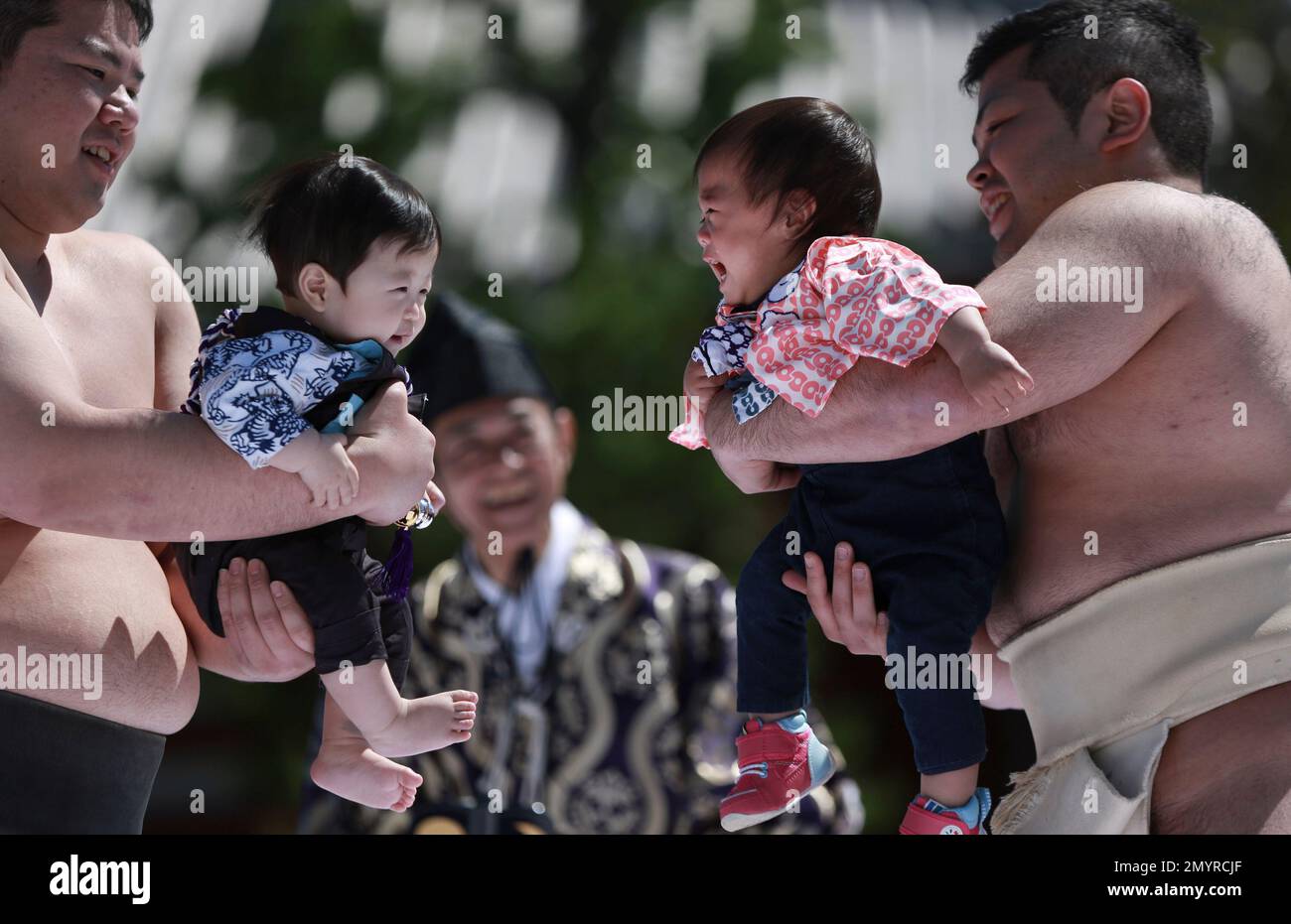 Held by college sumo wrestlers, a couple of babies cry in their Naki ...