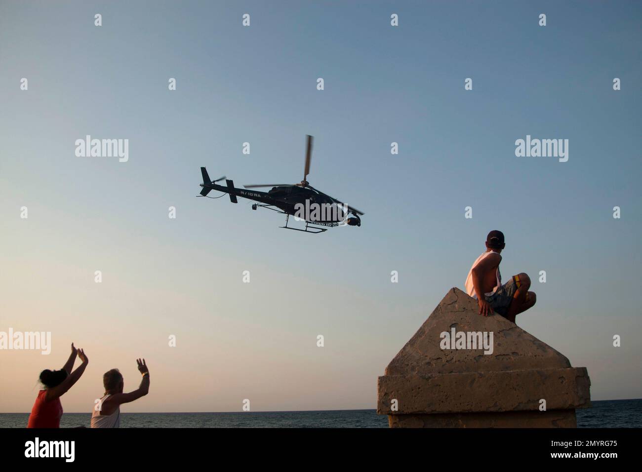 People watch a helicopter during filming of the latest installment of ...