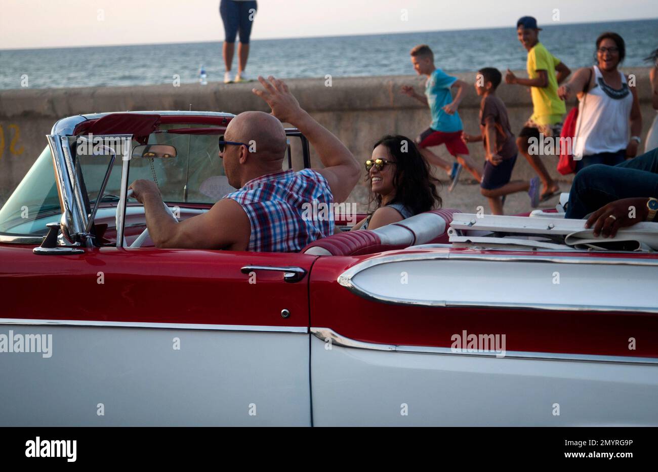 U.S. Actor Vin Diesel drives a vintage American car next to actress ...