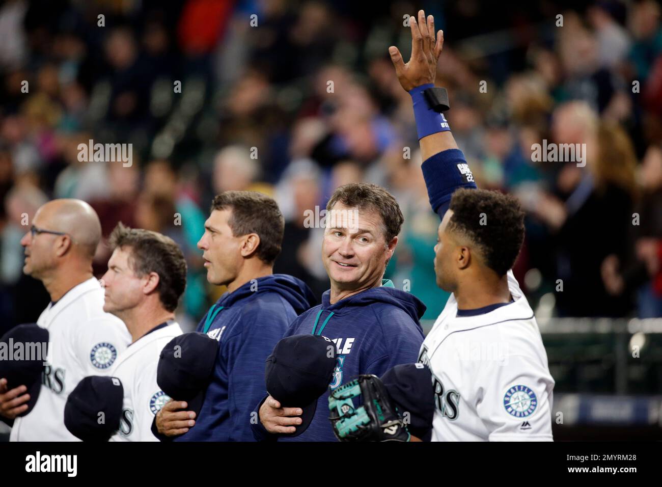 Seattle Mariners manager Scott Servais, second right, turns toward ...