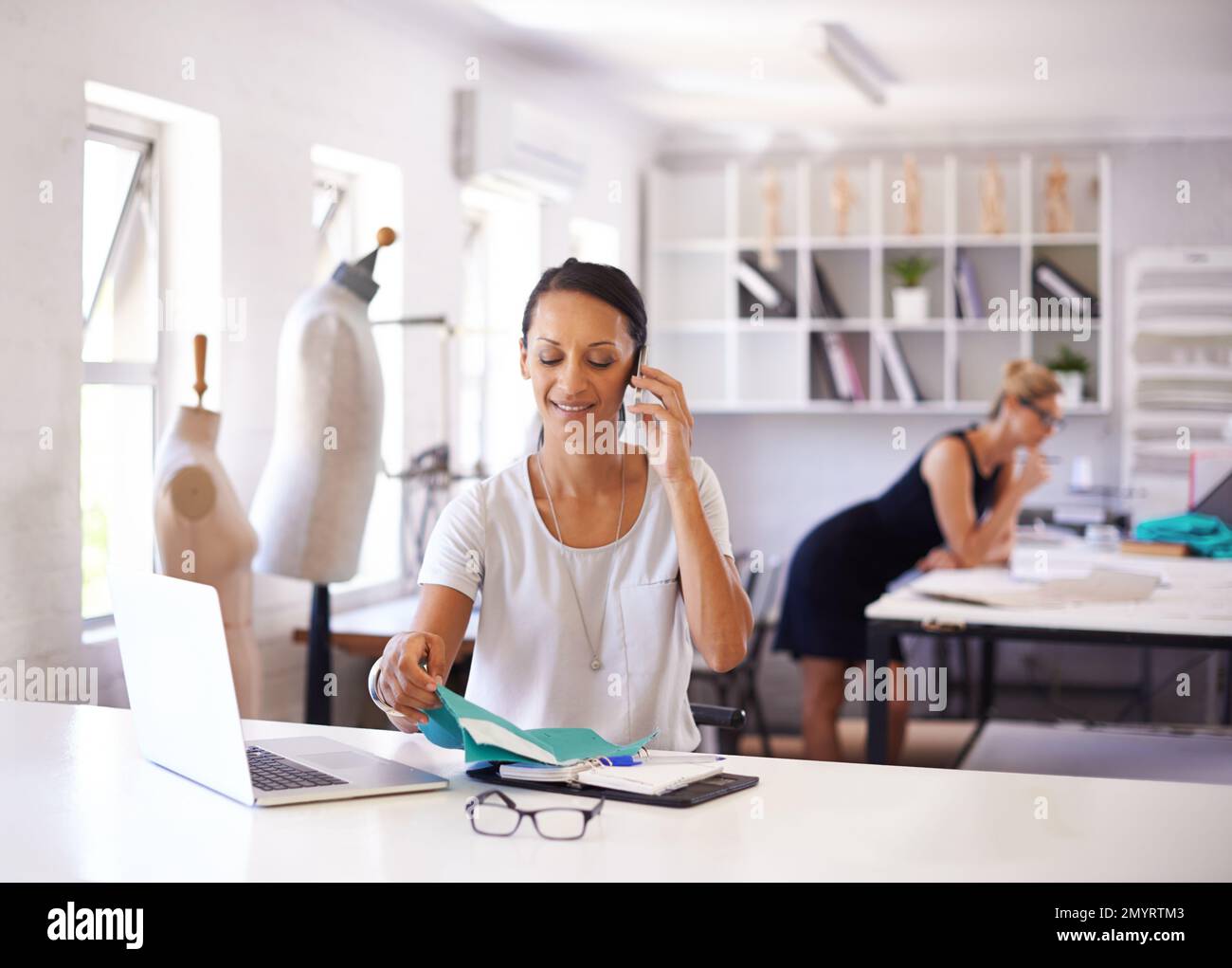 I have the fabric here now. two beautiful woman working in a clothing ...