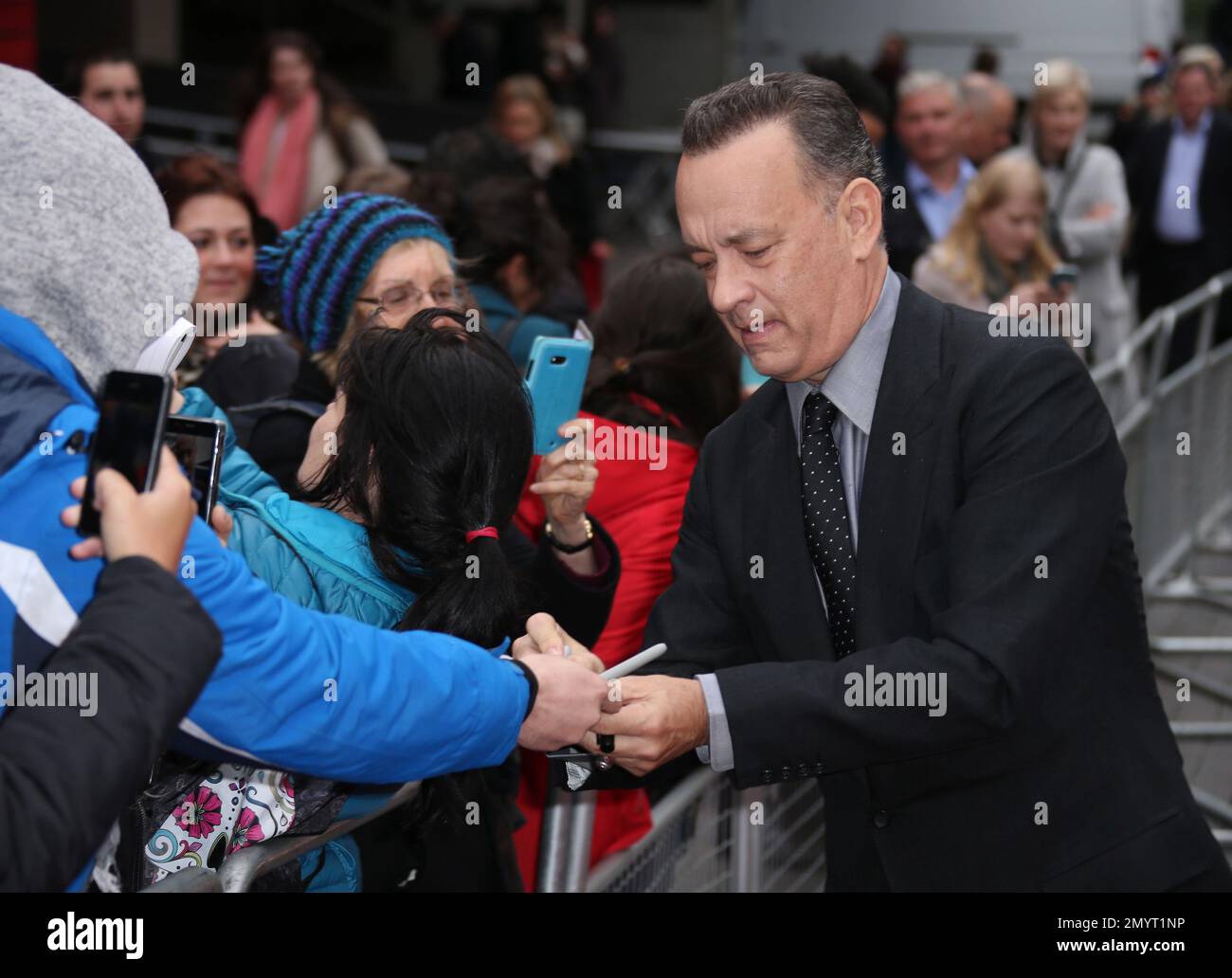 Actor Tom Hanks signs autographs upon arrival at the premiere of the ...