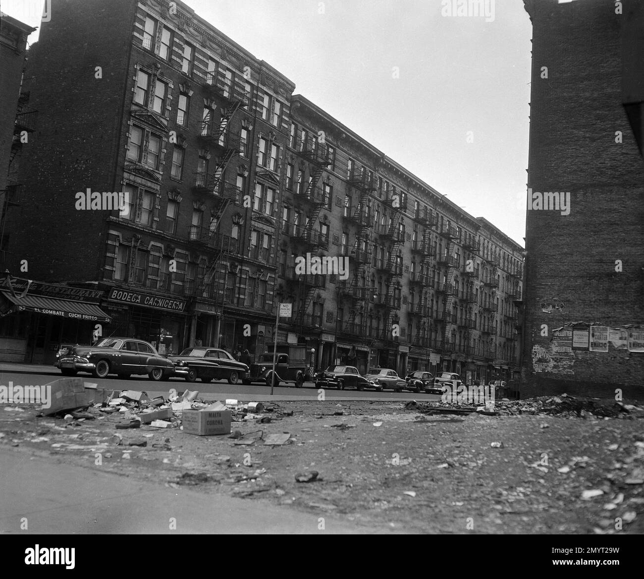 Garbage strewn vacant lot across the street from tenement buildings on ...