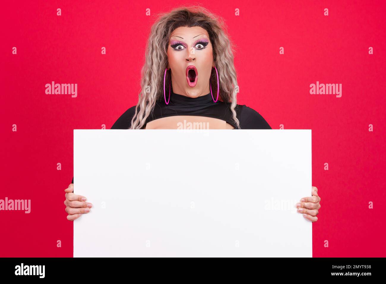 Surprised transgender person holding a blank panel in studio Stock ...