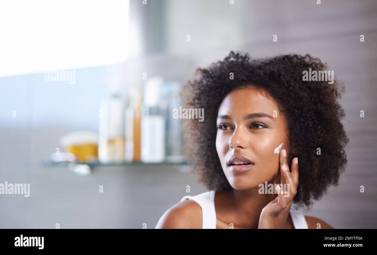 Keeping My Face Silky Smooth An Attractive Young Woman Applying Cream