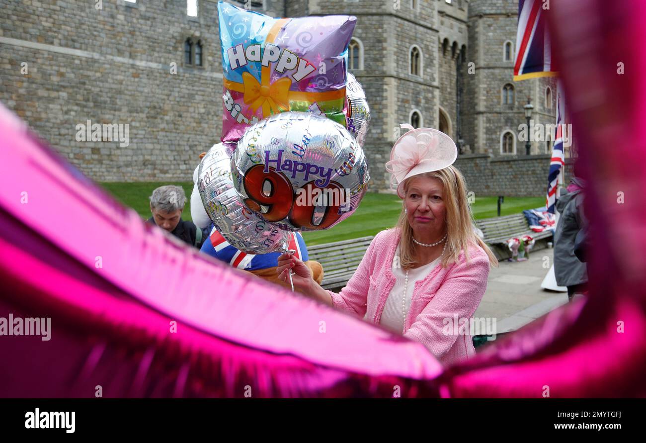 Royal fans gather with placards, flags and balloons as they wait for Britain's Queen Elizabeth ...