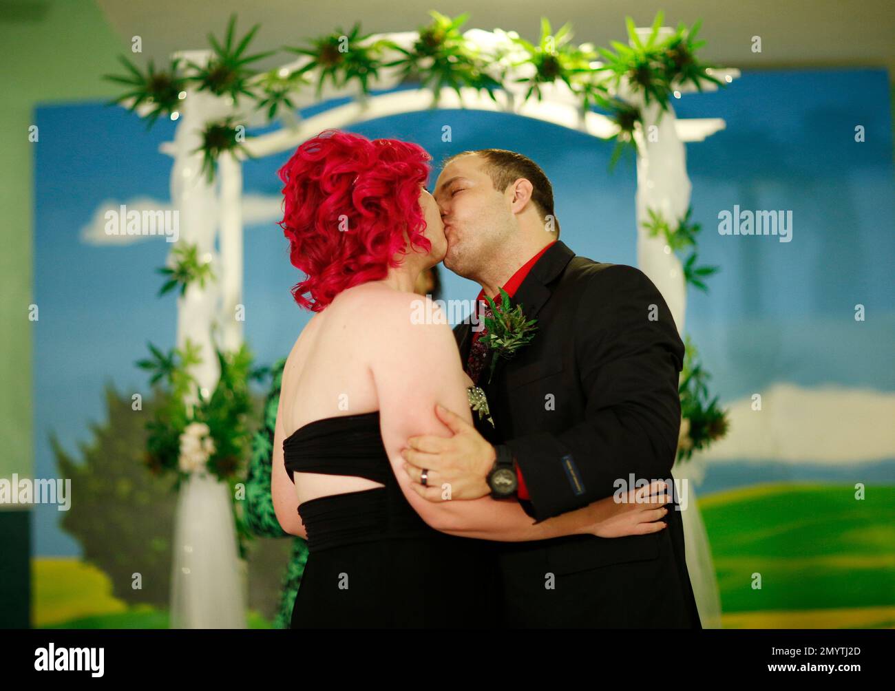 Natalie Rice, left, kisses her new husband Lee Rice beneath a canopy of ...