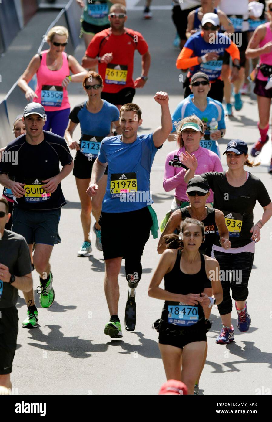 Boston Marathon bombing survivor Patrick Downes raises his fist as he ...