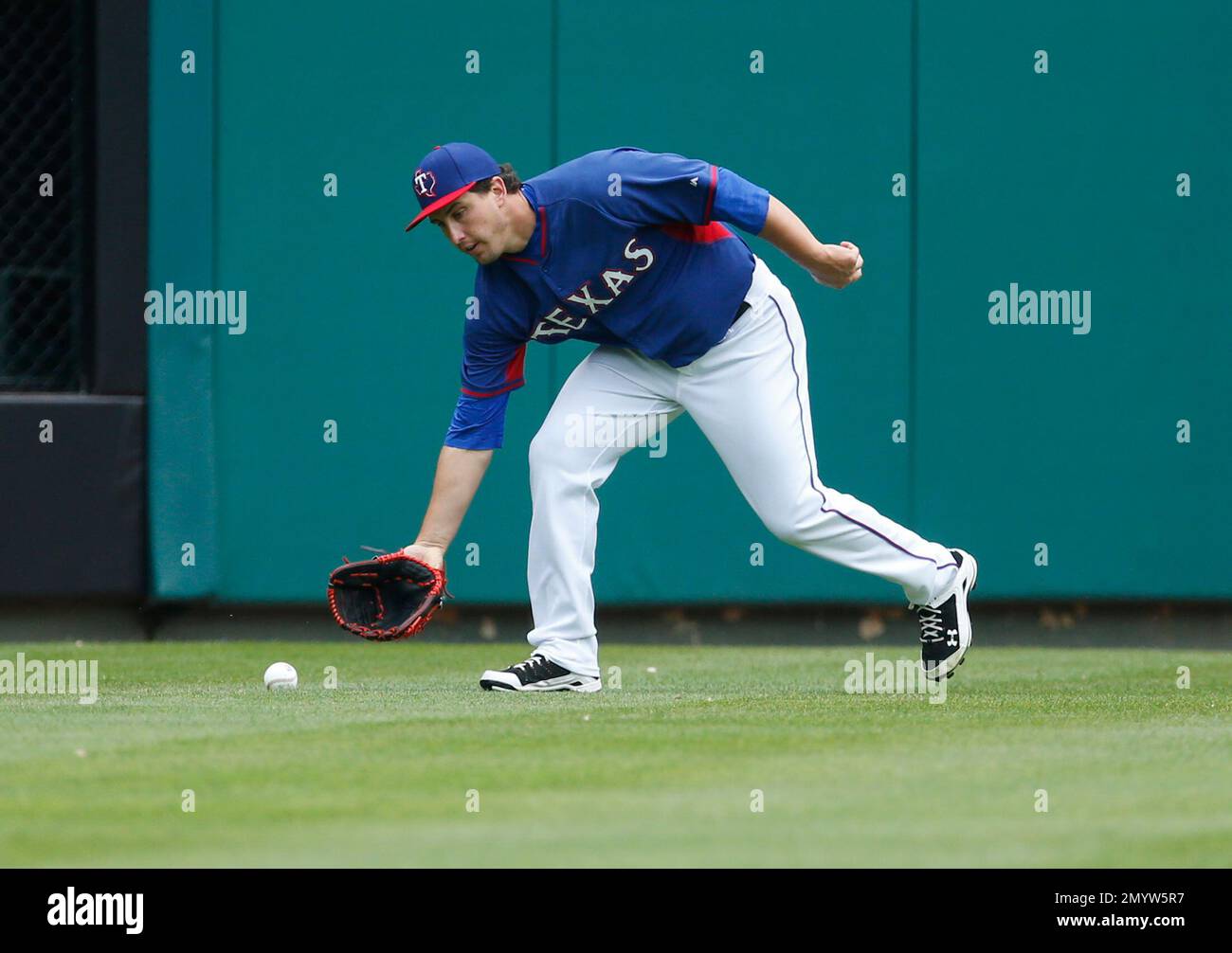 Texas Rangers' Derek Holland fields a ball during team warm-ups before ...