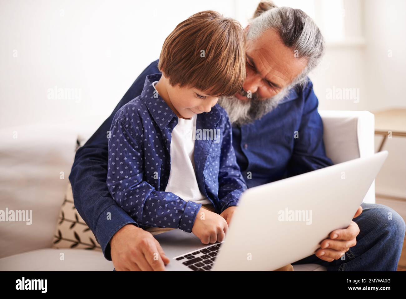Look how smart I am grandpa. a grandfather and grandson using a laptop ...