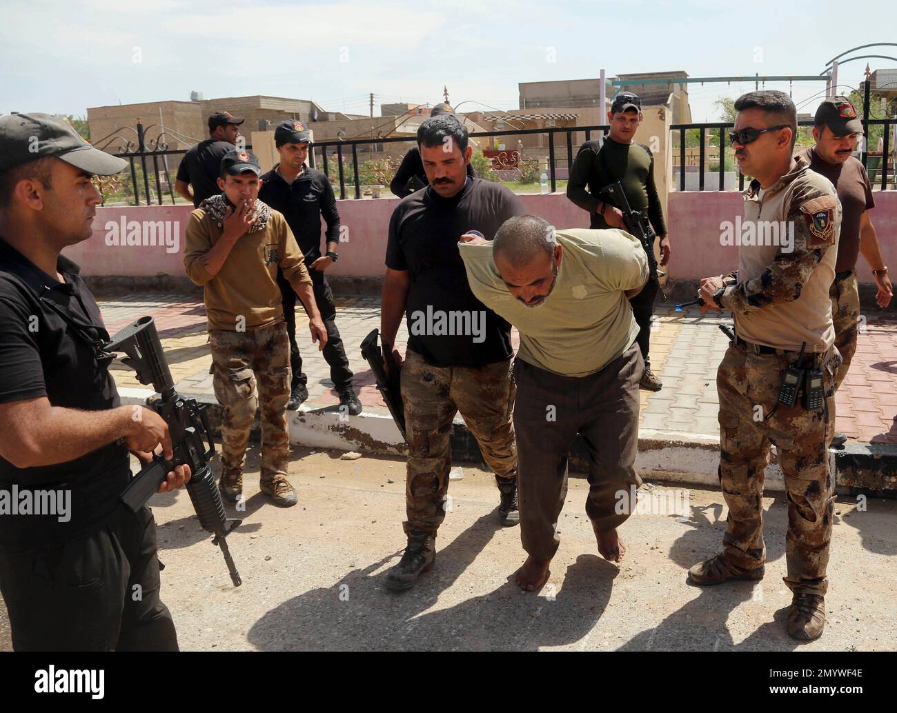 Iraqi security forces arrest a suspected fighter with the Islamic State ...