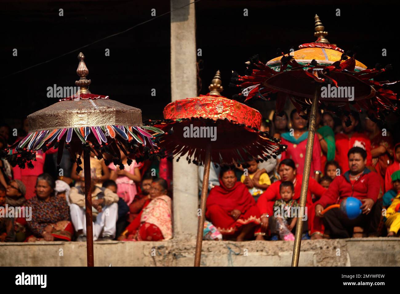 Nepalese devotees gather to watch the procession as holy umbrellas are ...