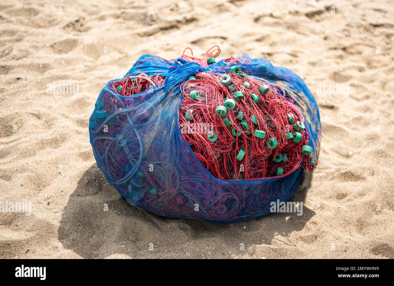 Fishing nets collected on sand beach. big bale of fishing nets. nylon ...