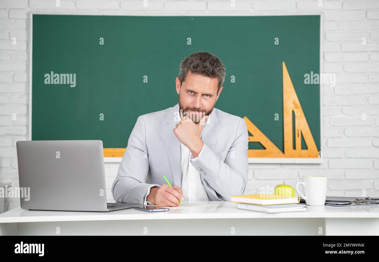 thinking school teacher in classroom with laptop at blackboard Stock ...