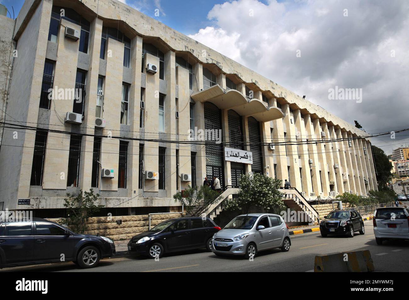 People and policemen stand at the entrance of the courthouse compound ...