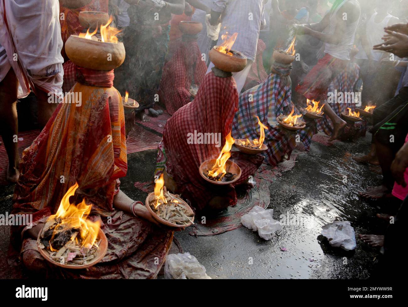 Hindu devotees perform a ritual balancing fire pots on head and hands ...
