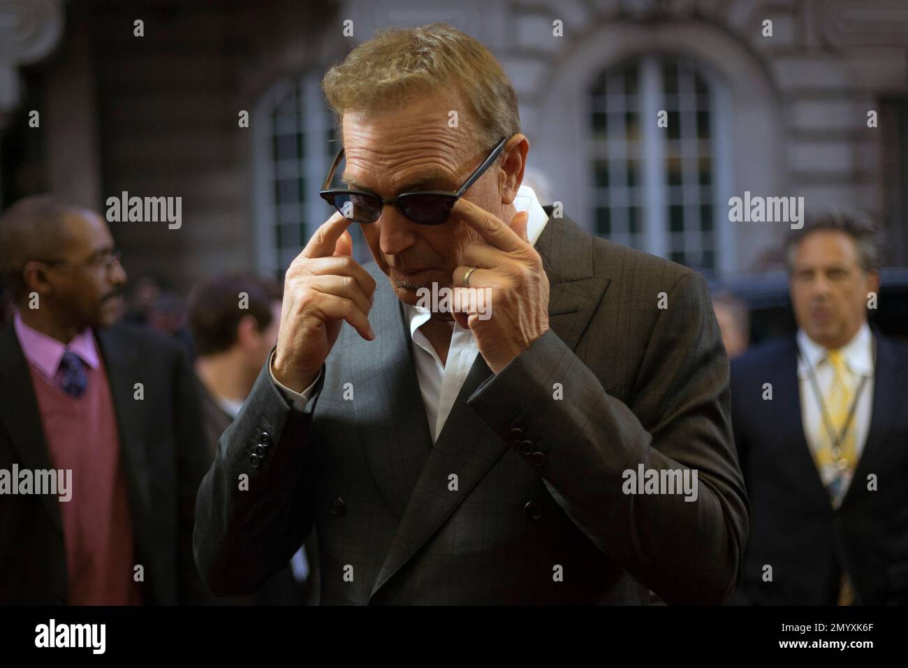 Actor Kevin Costner rubs his eyes as he poses for photographers upon ...