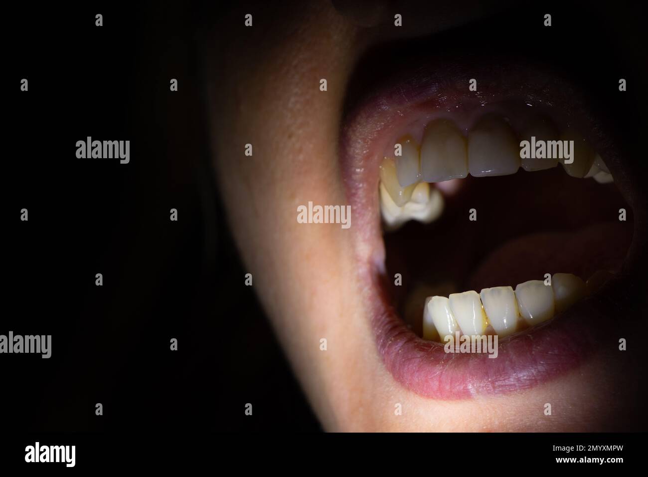 female mouth in the dark illuminated by a lantern Stock Photo - Alamy