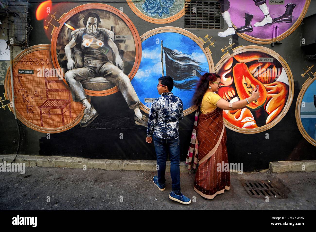 People take selfies in a colorful slum surroundings with beautiful wall ...