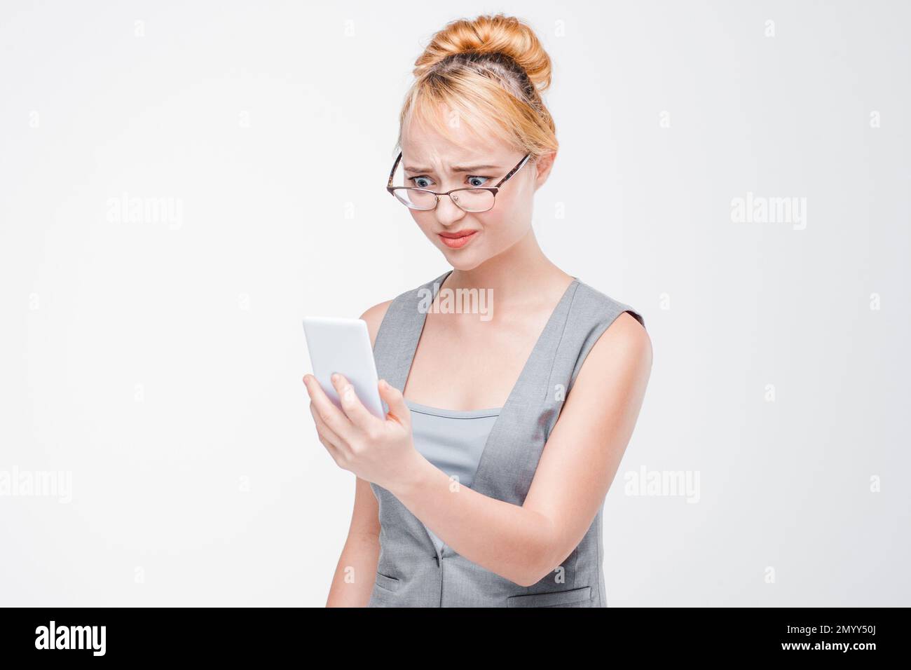 Young girl look at phone with disgust and aversion Stock Photo - Alamy