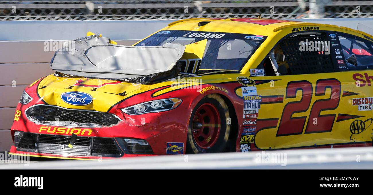 Driver Joey Logano (22) has his vision blocked by part of a hood repair ...