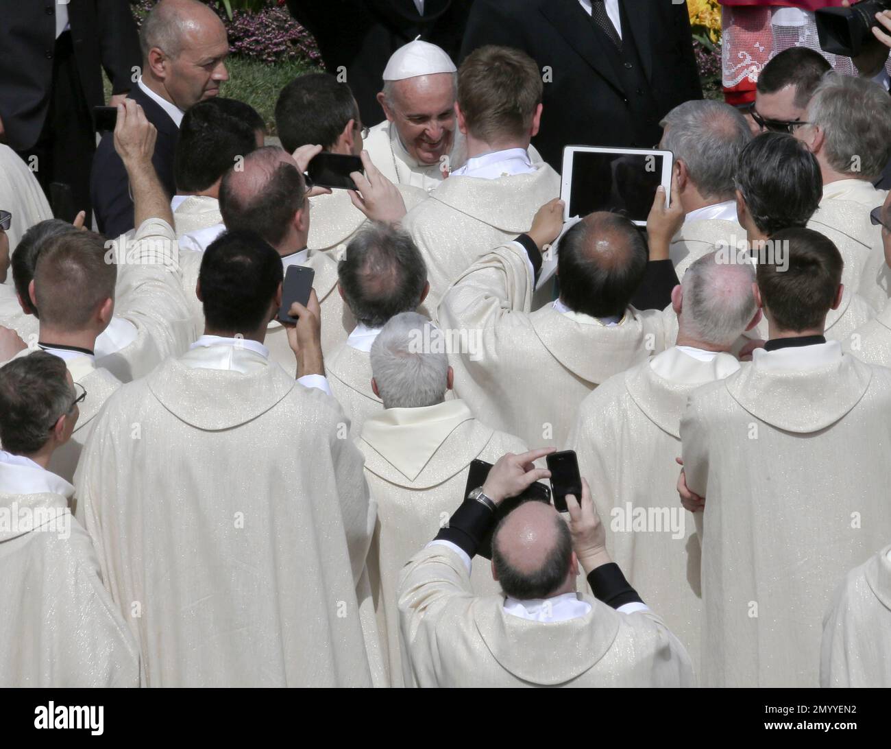 Priests take pictures with their phones as they wait to greet Pope ...