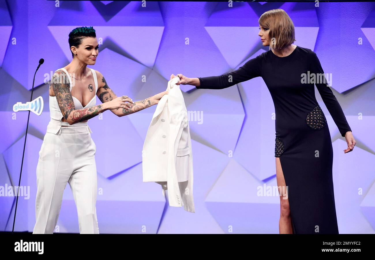 Actress Ruby Rose, left, hands her jacket to presenter Taylor Swift as ...