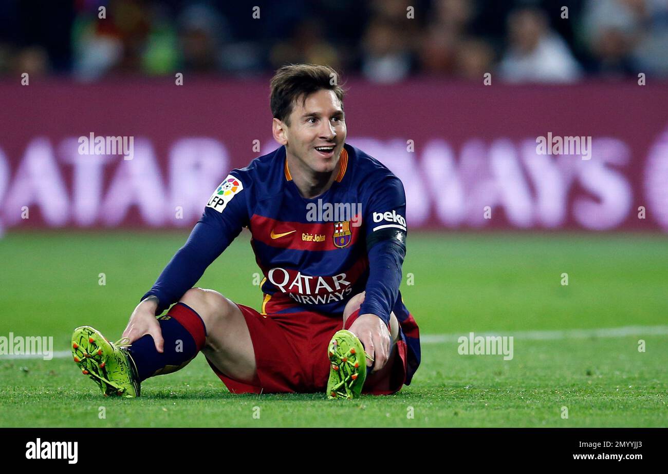 Barcelona's Lionel Messi sits on the ground following a clash during a ...