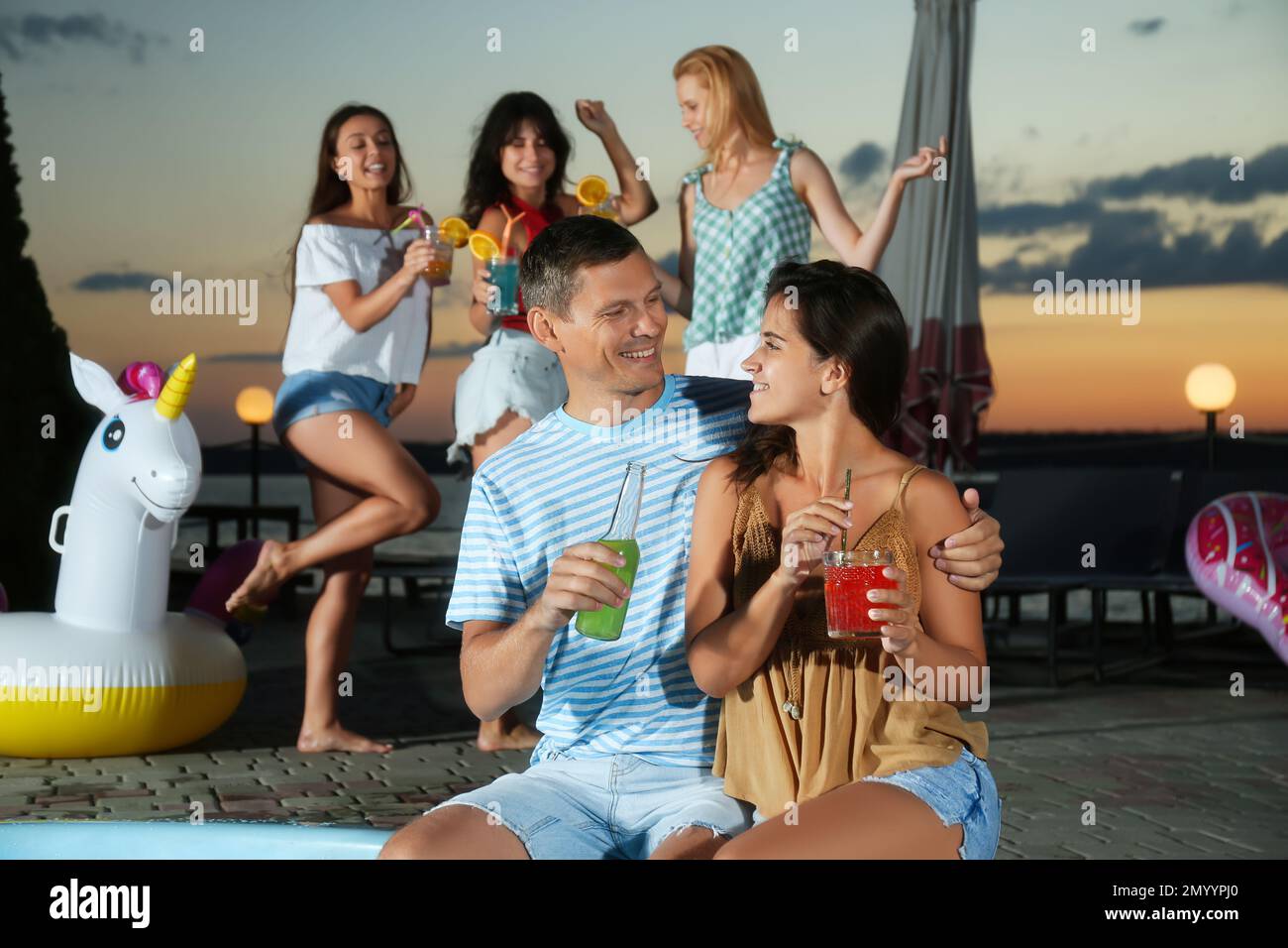 Group of happy people enjoying fun outdoor party in evening Stock Photo ...