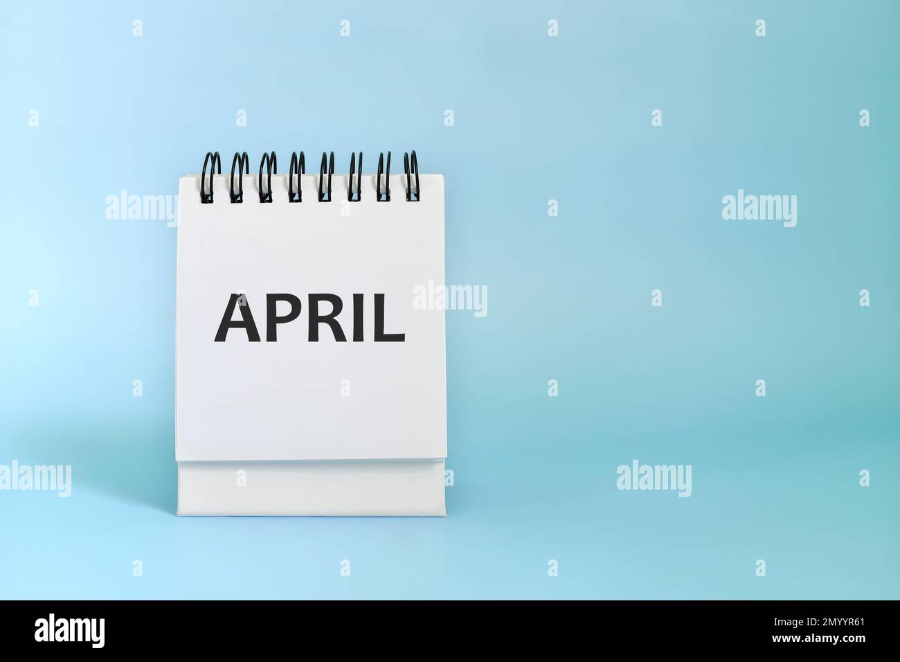 Selective focus of April desk calendar on blue background with spring ...