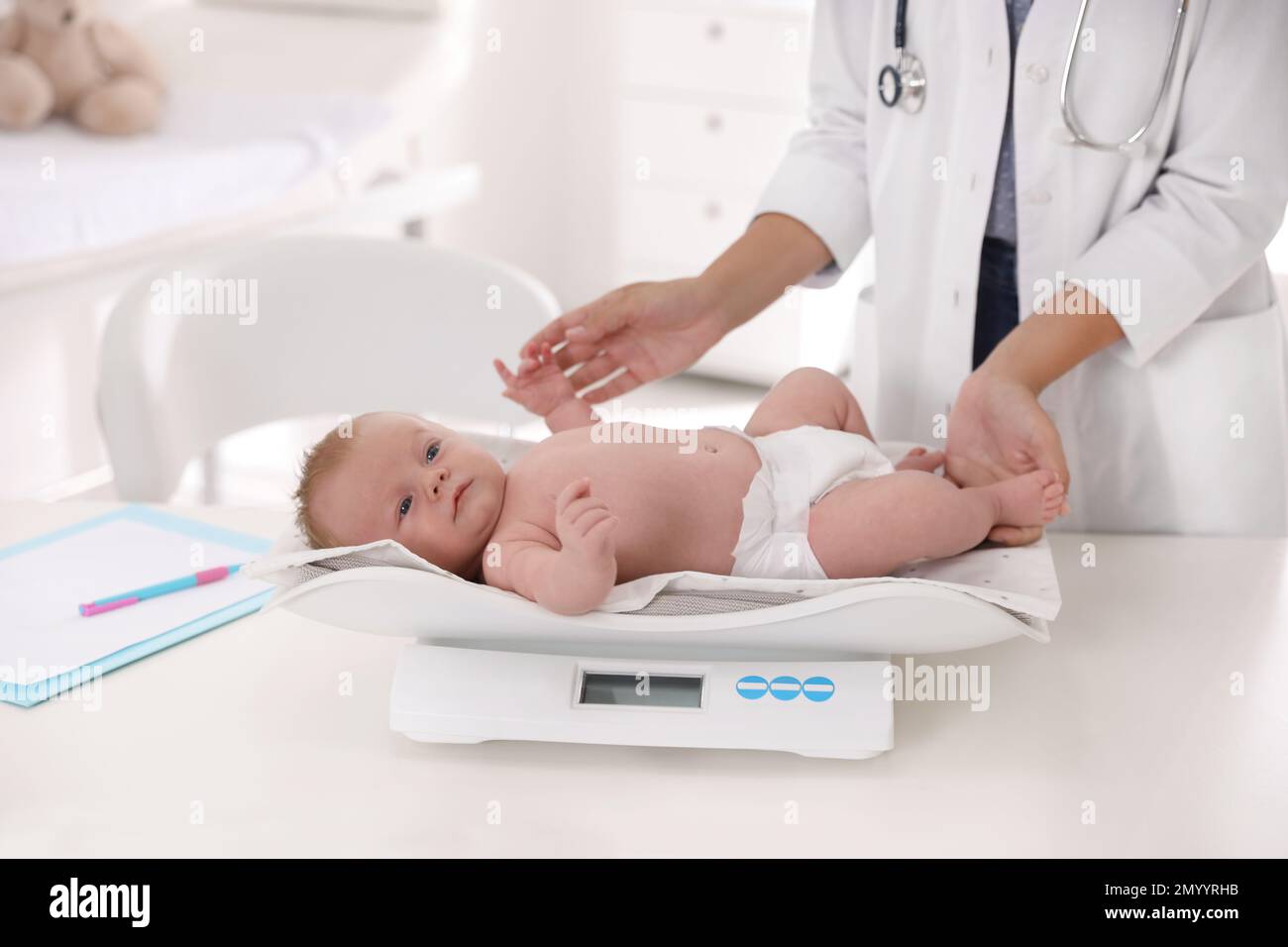 Doctor weighting cute baby in clinic, closeup. Health care Stock Photo ...