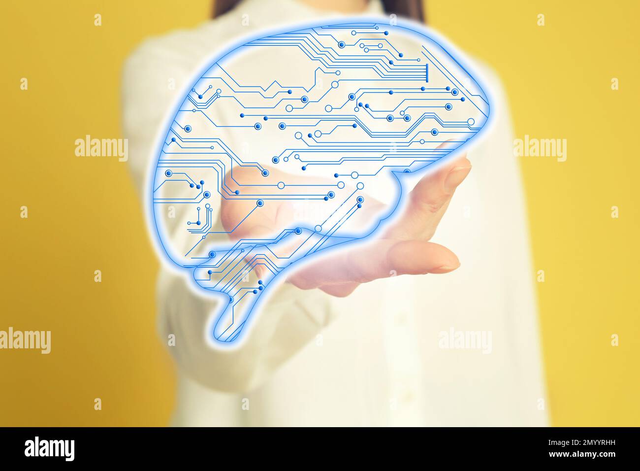 Woman demonstrating digital image of brain on yellow background ...