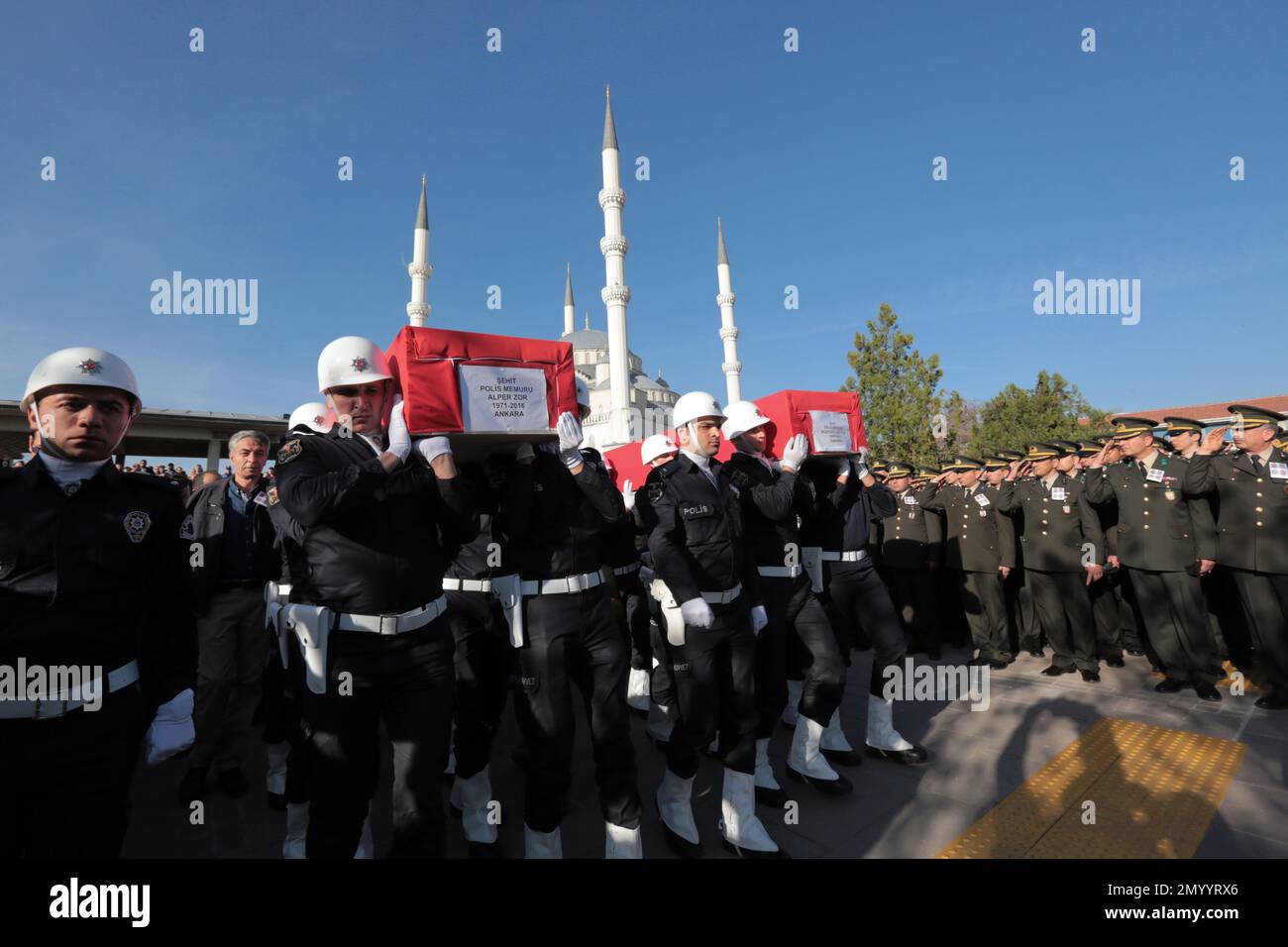 Turkish army officers salute as police officers carry the coffins of ...