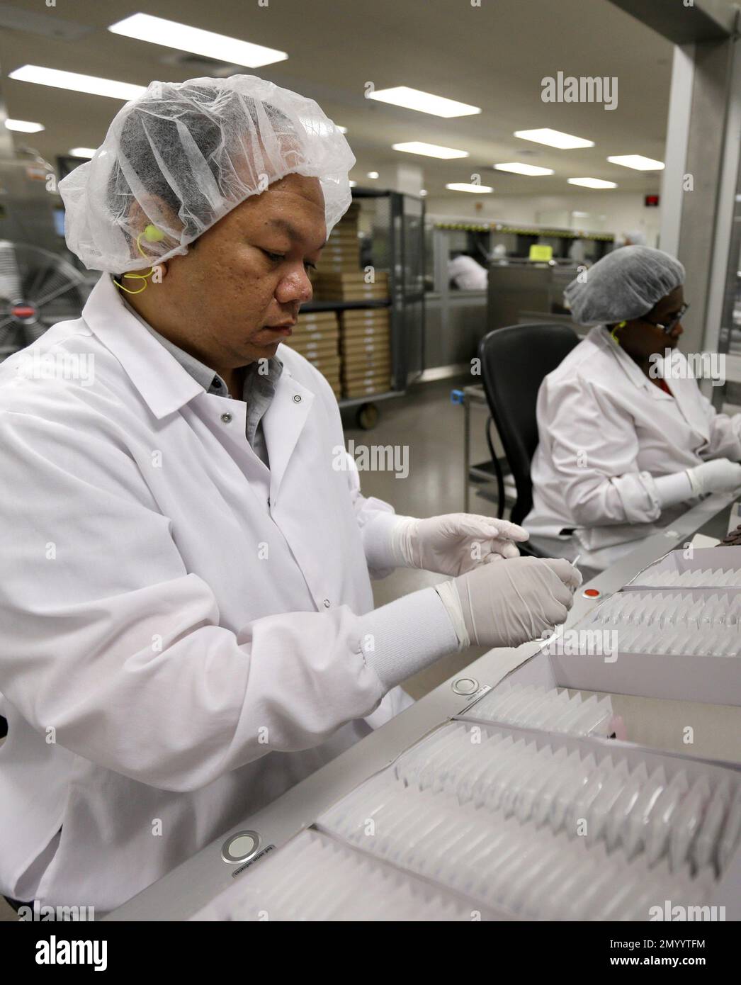 In this Monday, May 18, 2015, photo, Regin Trinidad, left, packages the ...