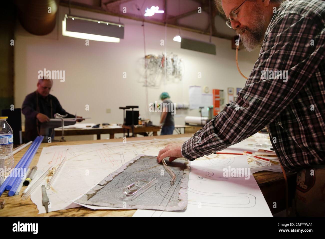 Greg Pond, co-founder of Neonworks of Cincinnati, right, lines up glass ...