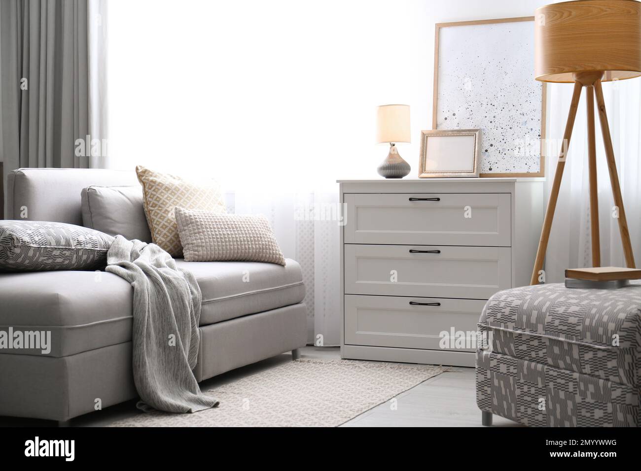 Modern stylish chest of drawers near window in living room. Interior ...