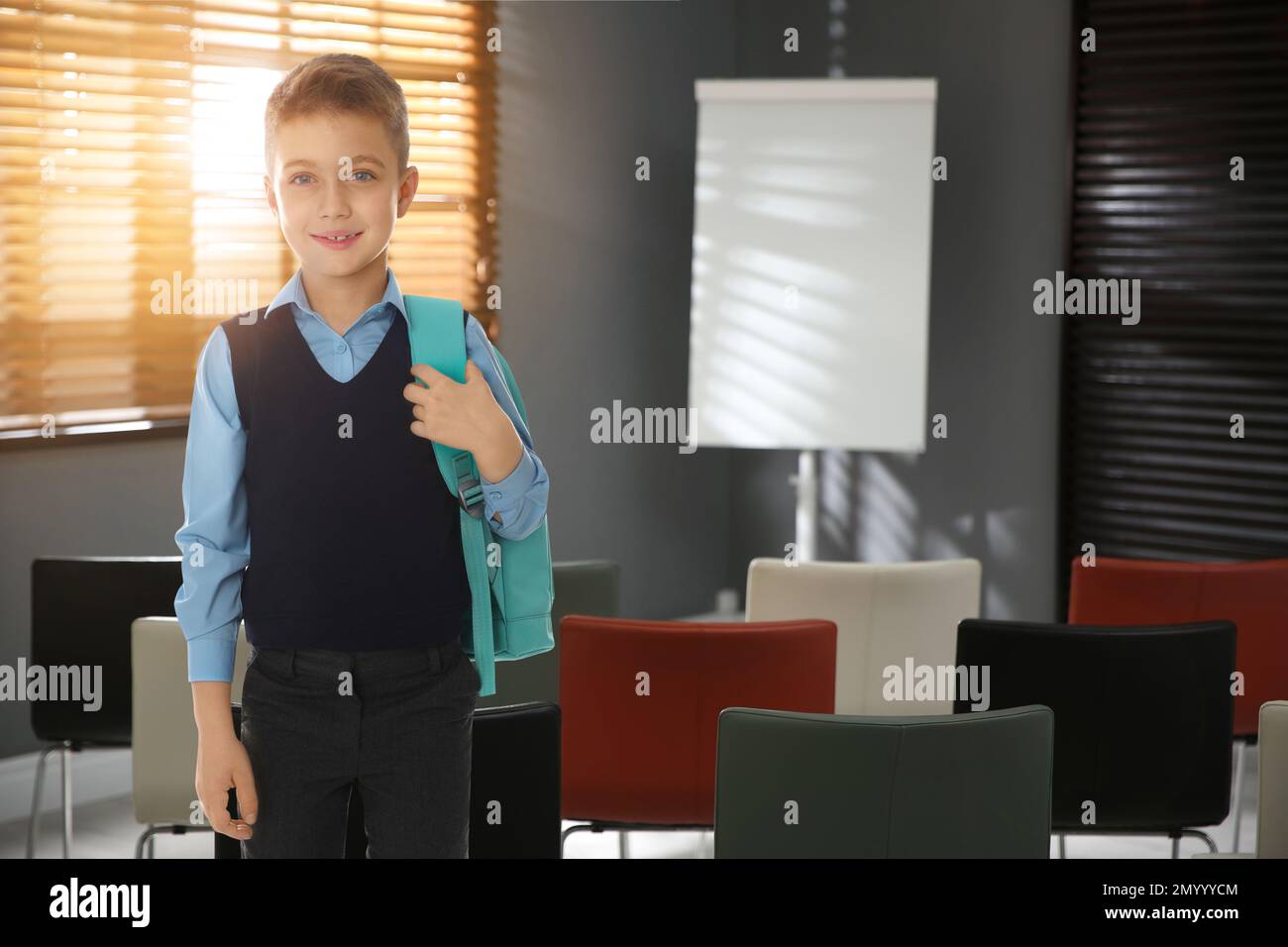 Little boy with backpack in empty school classroom Stock Photo - Alamy