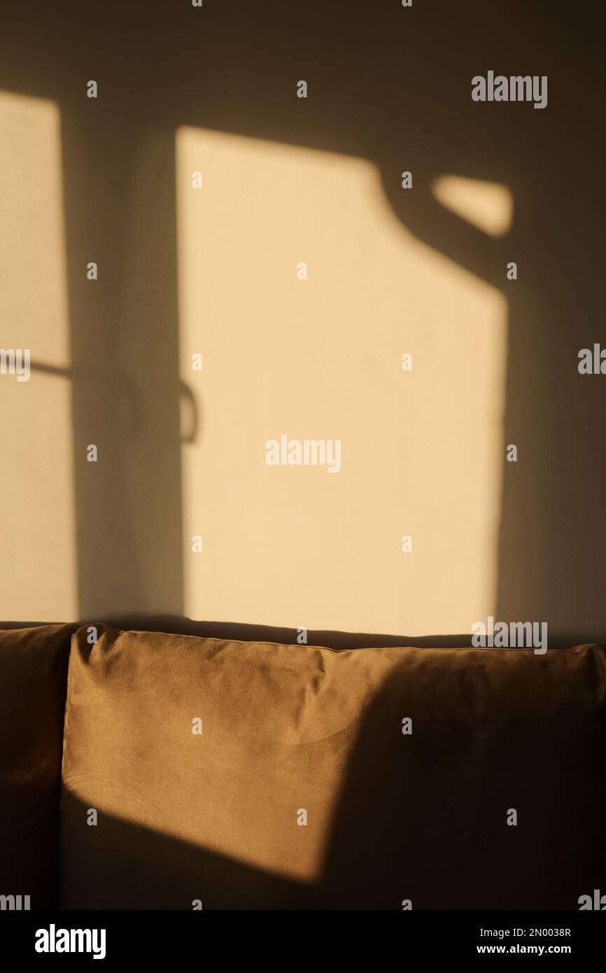 Indoor photo of shadow patterns on wall and couch during sunset ...
