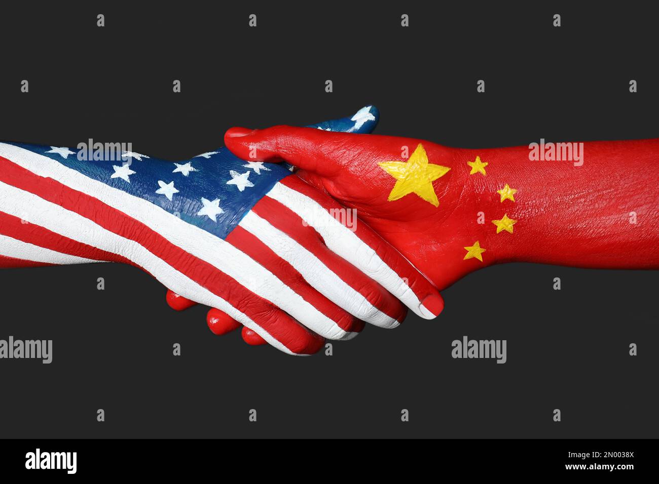 USA and China partnership. People shaking hands painted in flags on ...
