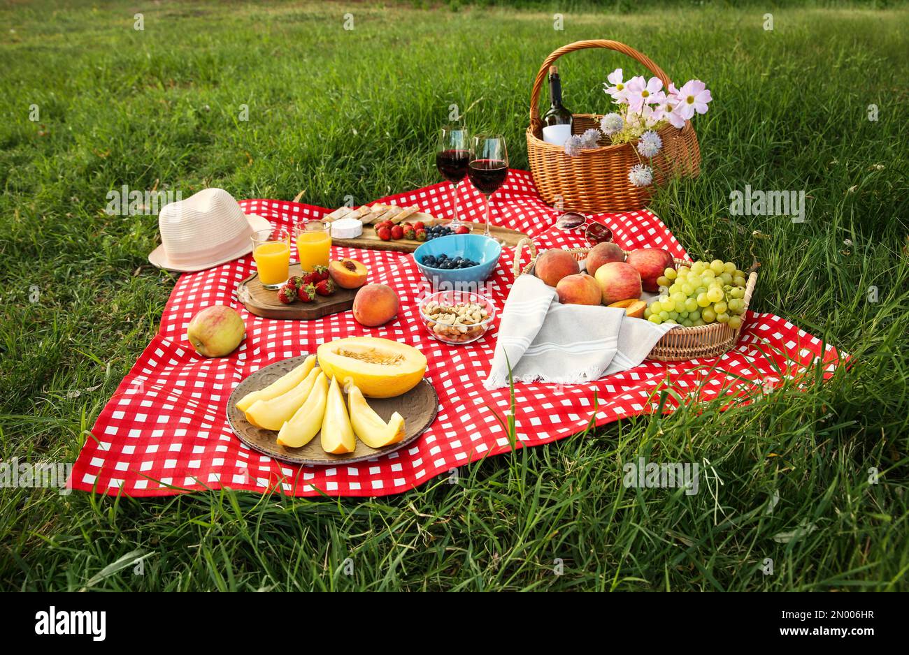 Picnic blanket with delicious food and drinks on green grass Stock ...