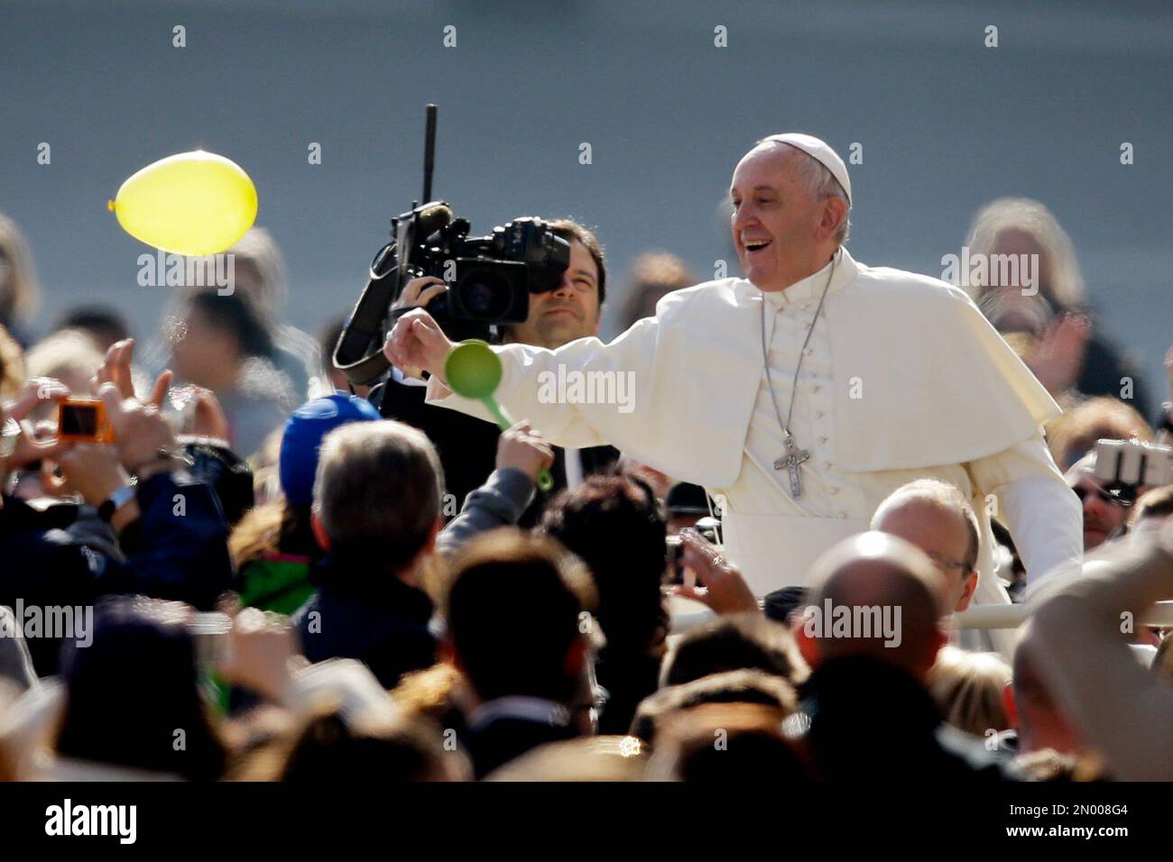 Pope Francis tries to reach for a flying balloon as he arrives with his ...