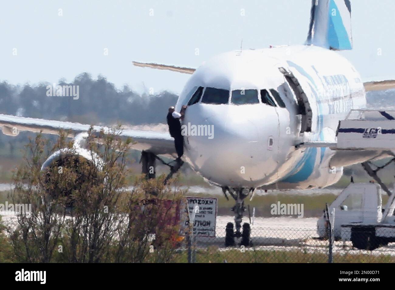 A man leaves the hijacked aircraft of Egyptair from pilot window at ...
