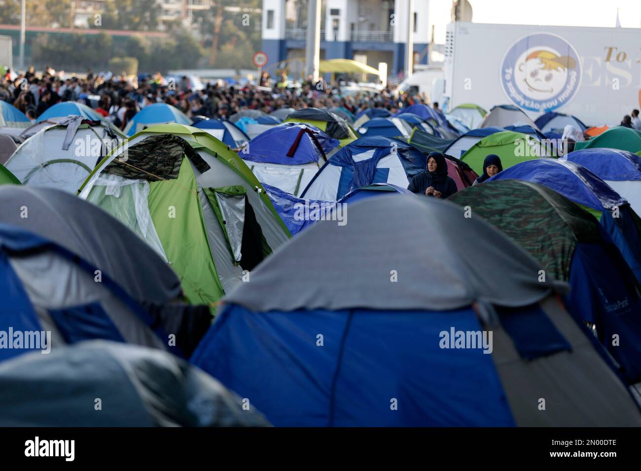Two women walk between tents at the Athens' port of Piraeus on Tuesday ...
