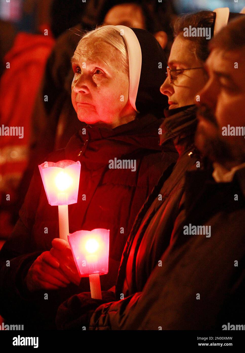 Nuns attend the Stations of the Cross procession through the streets ...